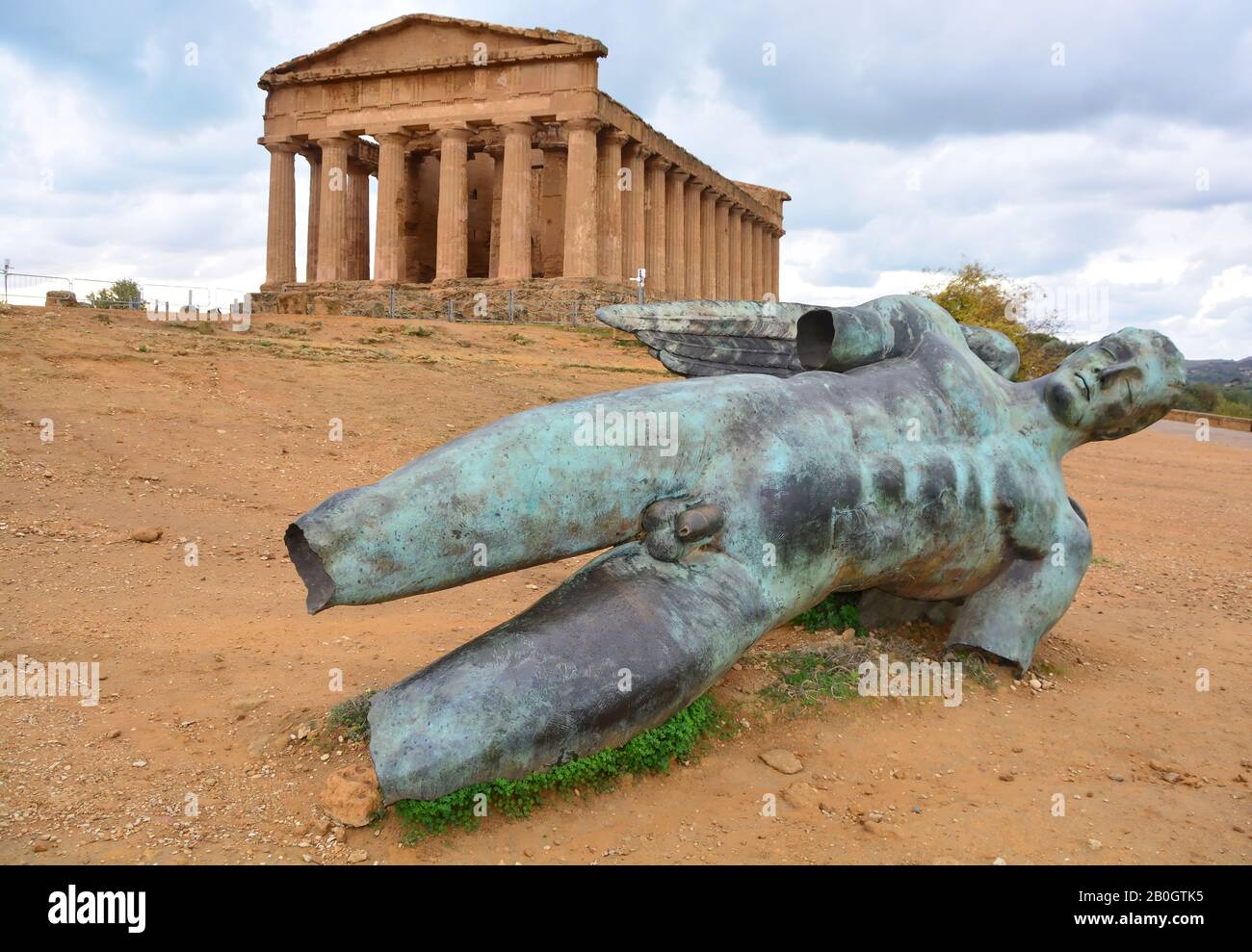 Statue of fallen Icarus in bronze in front of the 2,400 year old Temple ...