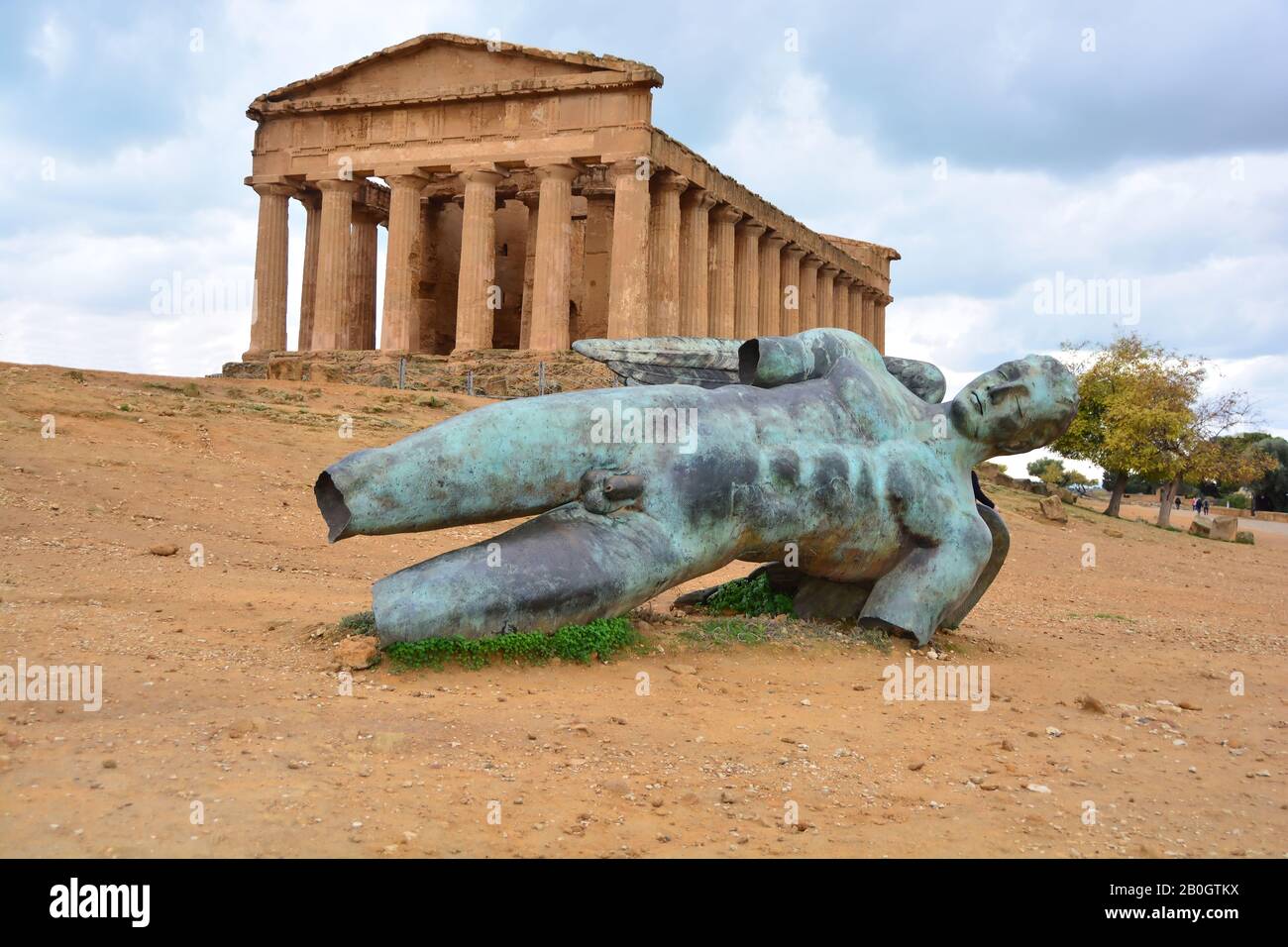 Statue of fallen Icarus in bronze in front of the 2,400 year old Temple ...