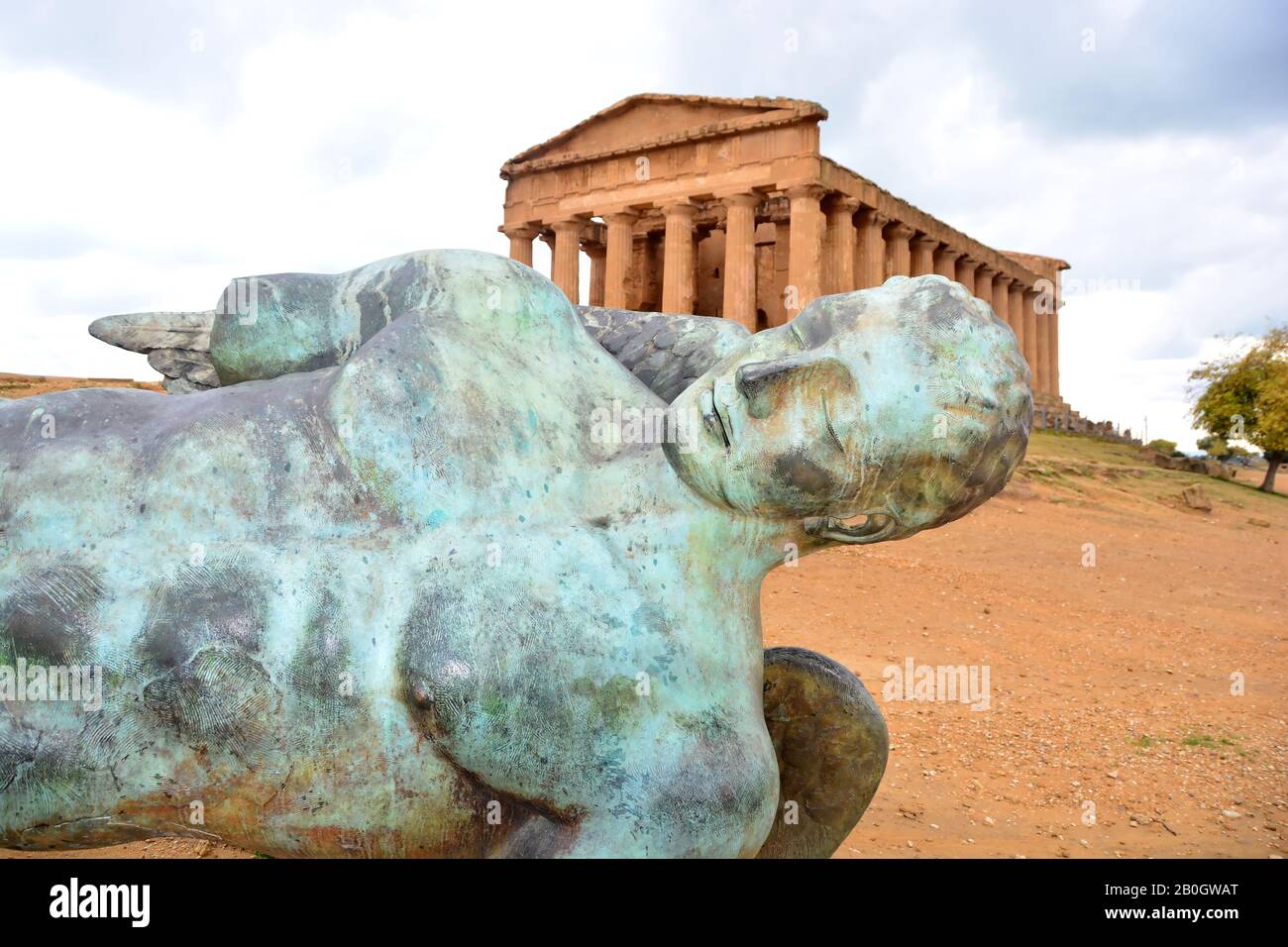 Statue of fallen Icarus in bronze in front of the 2,400 year old Temple ...