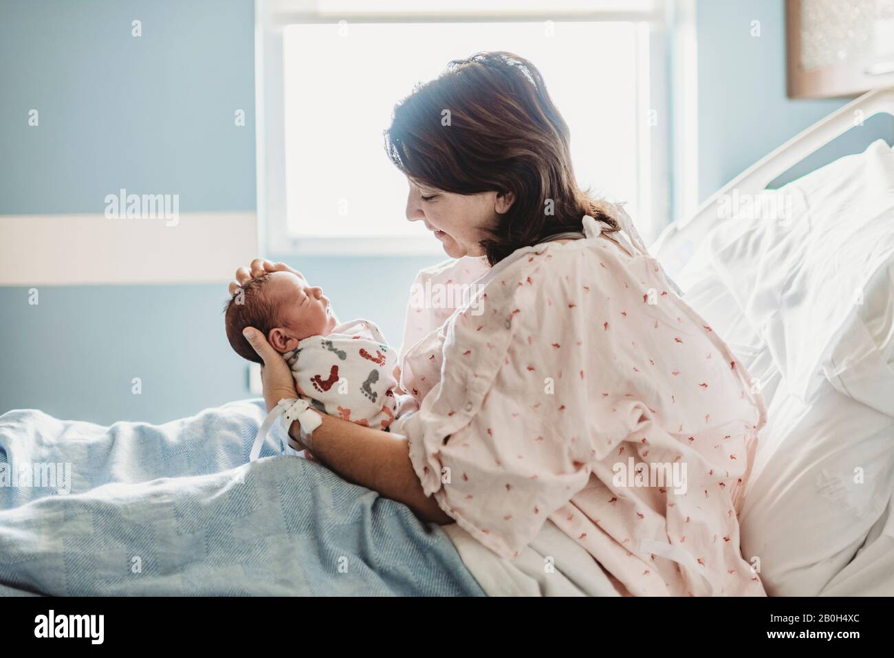 Side view of mother looking lovingly at newborn son in hospital Stock ...