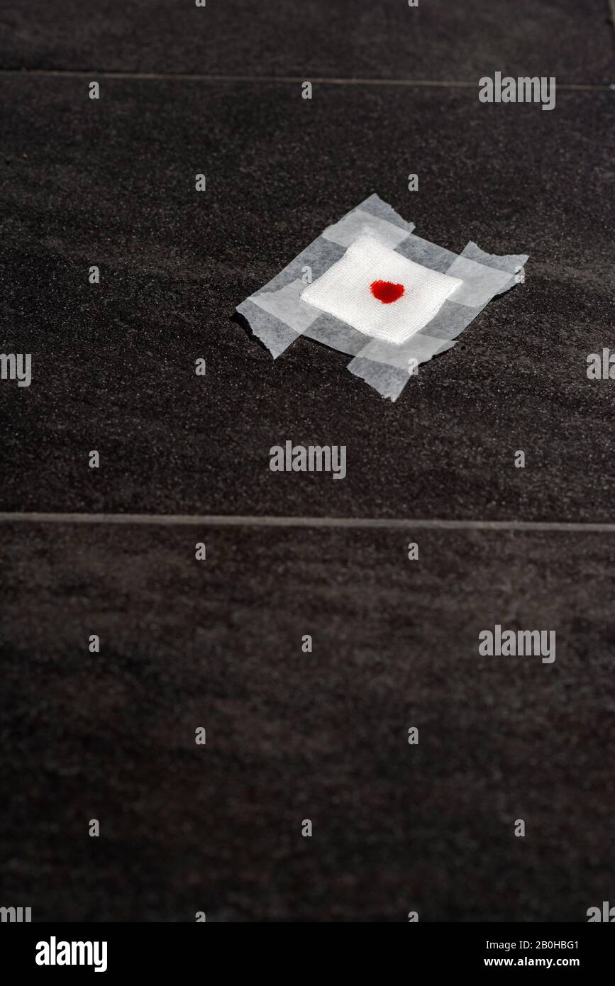 Bandage mesh with blood on grey tile floor. Top view Stock Photo - Alamy