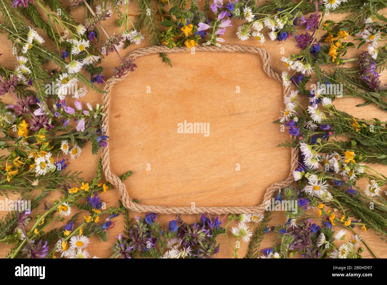 Wildflowers and rope on a wooden background. View from above. Spring ...