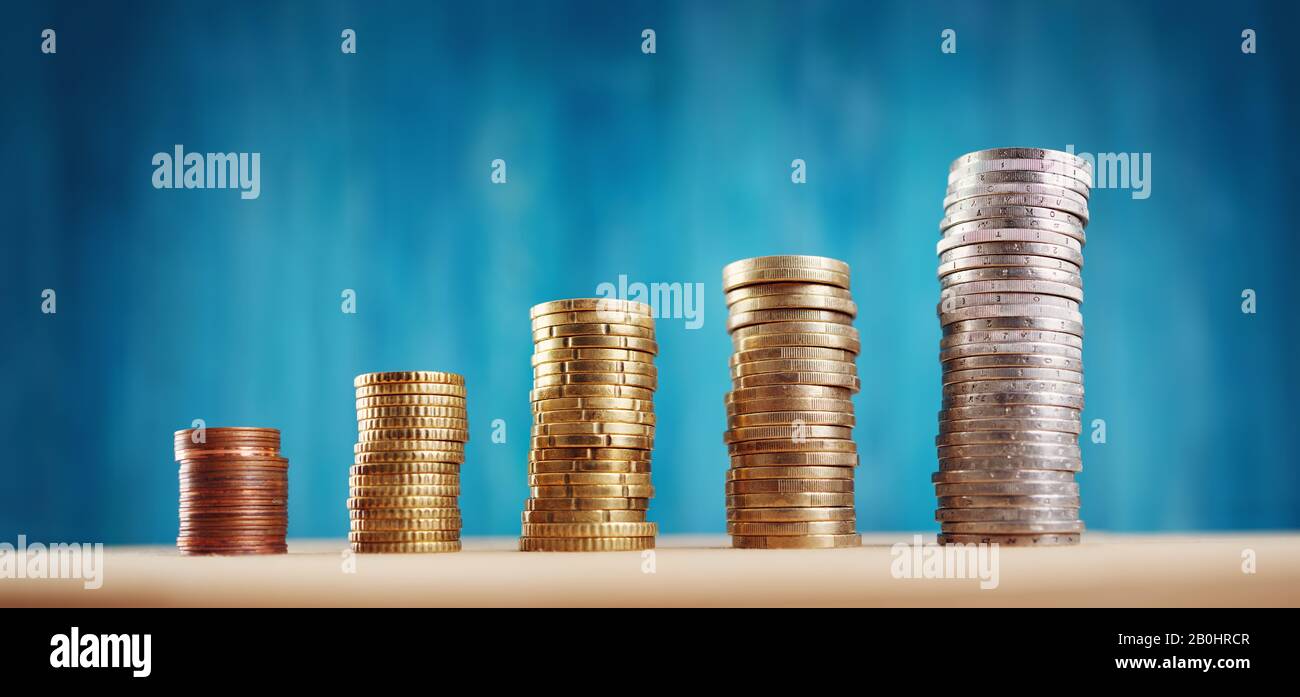 stacked coins on blue background. Money columns Stock Photo - Alamy