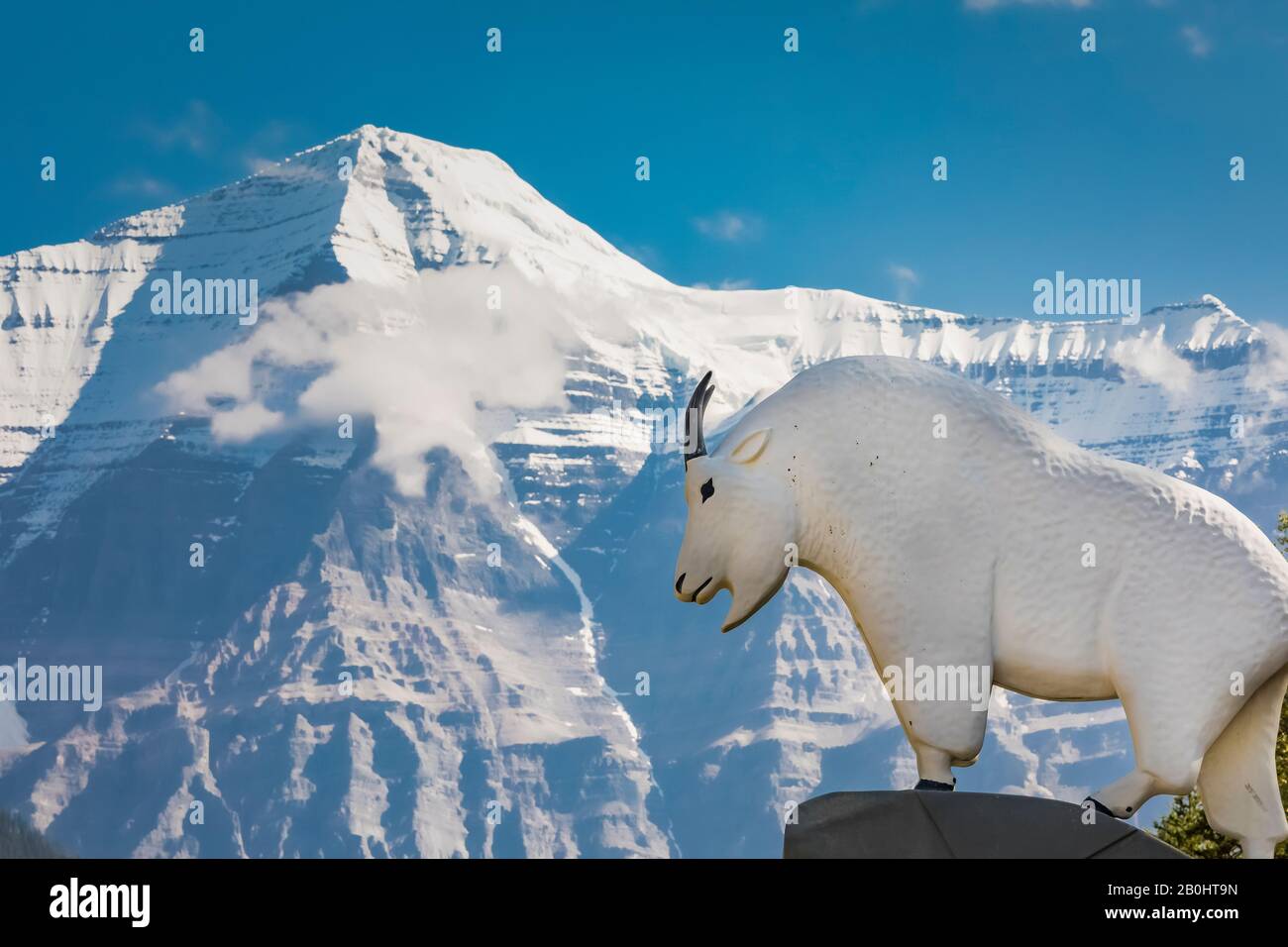 Entrance sign with carved Mountain Goat and Mount Robson towering ...