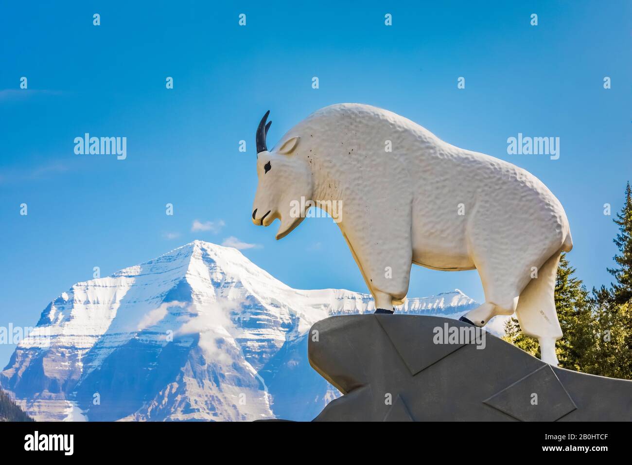 Entrance sign with carved Mountain Goat and Mount Robson towering ...