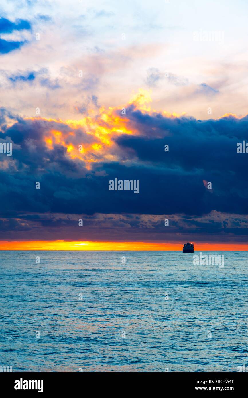Sea sunset landscape with cloud sun reflection and ship on the horizon ...