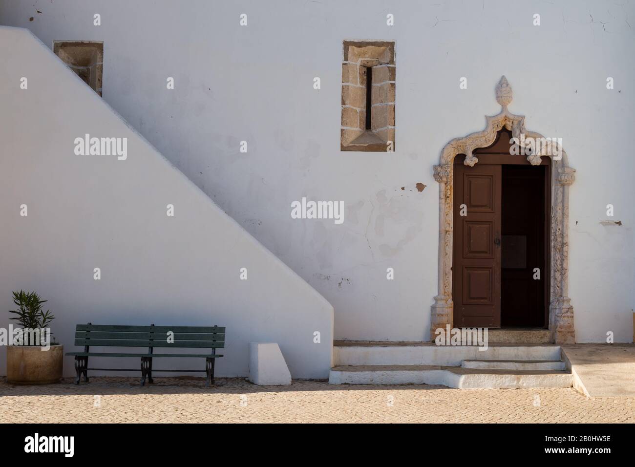 Side wall and entrance to the church Igreja Matriz de Alvor. Ornate ...