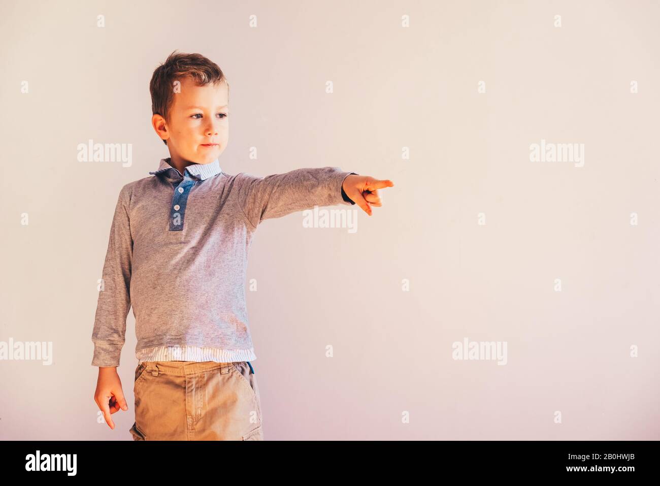 Child pointing with raised hand and finger pointing up, blank space ...