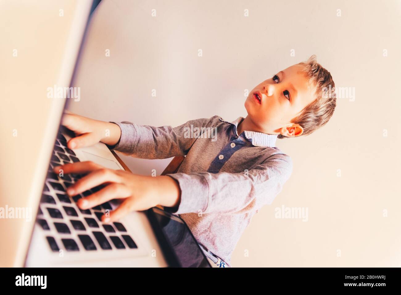 Child working with his computer in his business, concentrated typing to ...