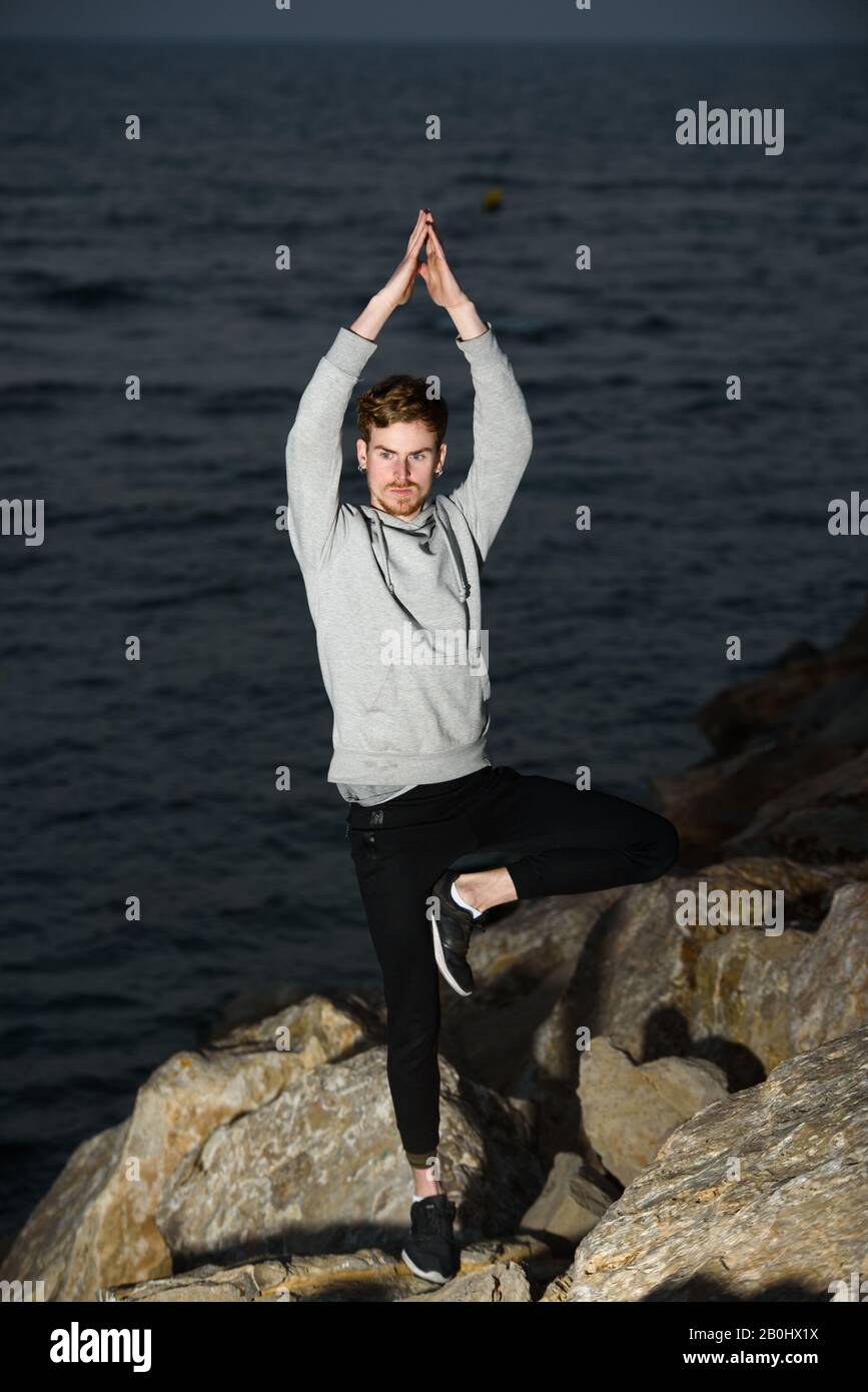 Young man in a Namaste greeting position while freeing his mind from ...