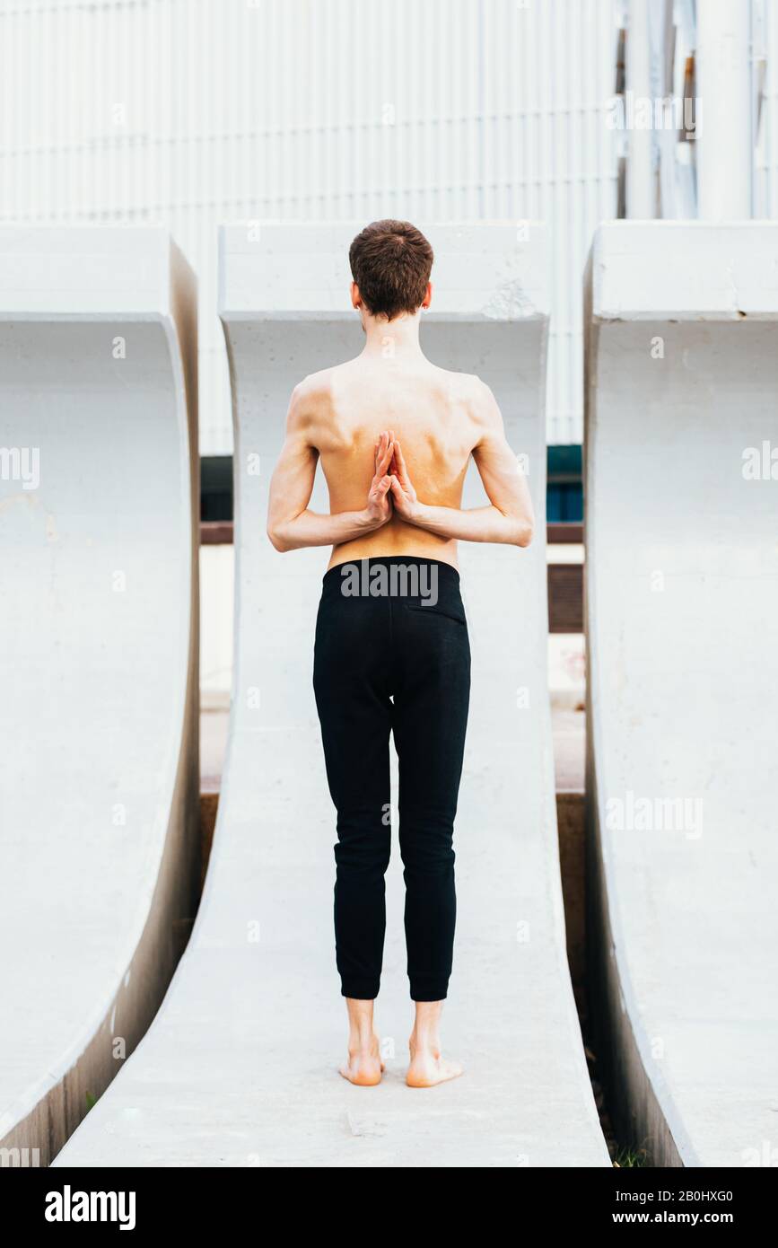 Yoga posture inverted prayer or Namaste hands on the back performed by ...