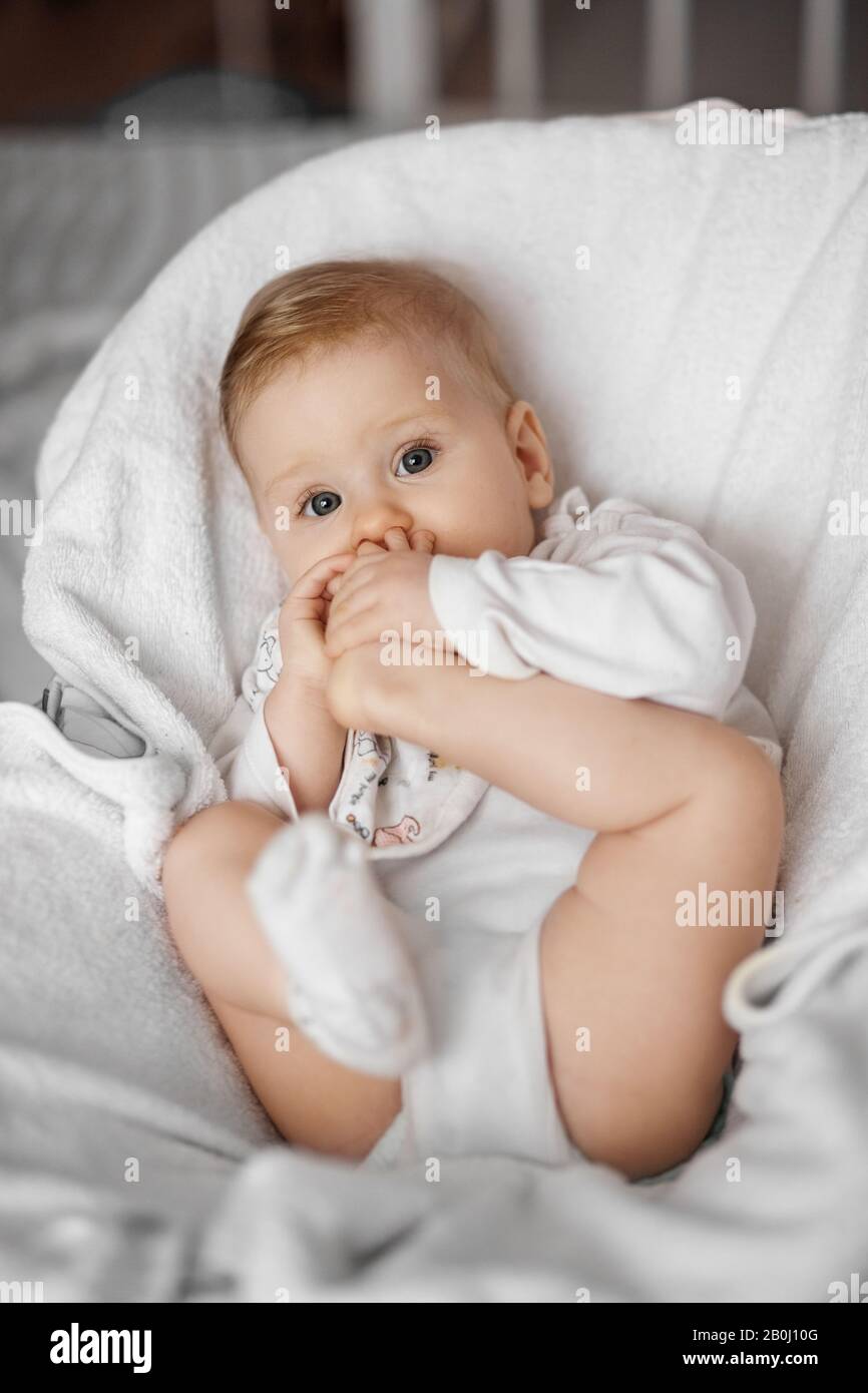 Little infant lies and bites his leg. The concept of motherhood, child ...