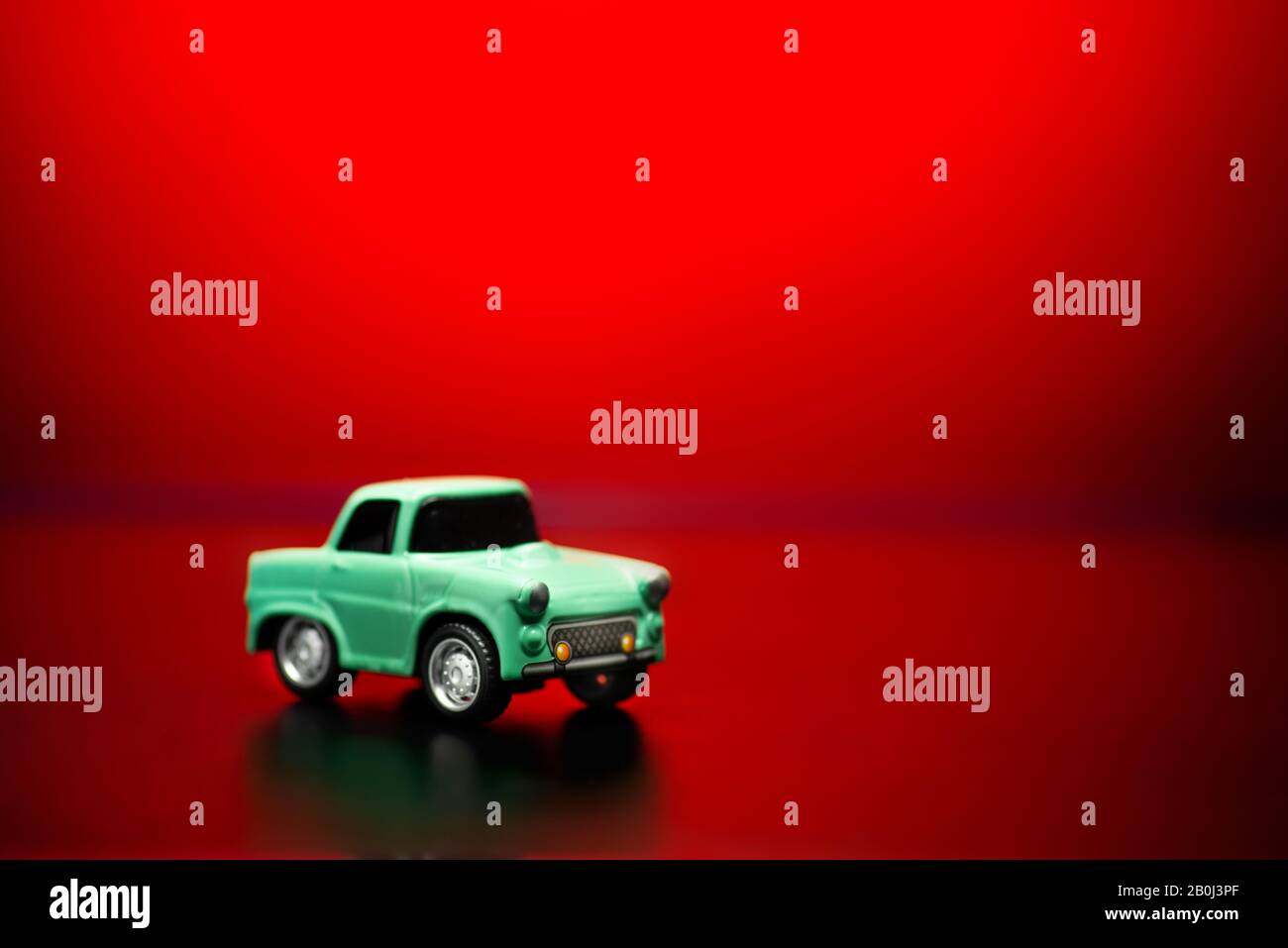 Side view of a Yellow colored toy model car on a red background Stock ...