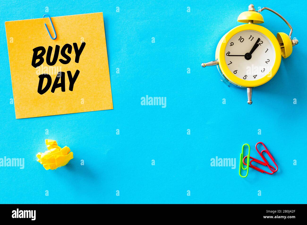 yellow alarm clock on blue background, Card with the words "busy day ...