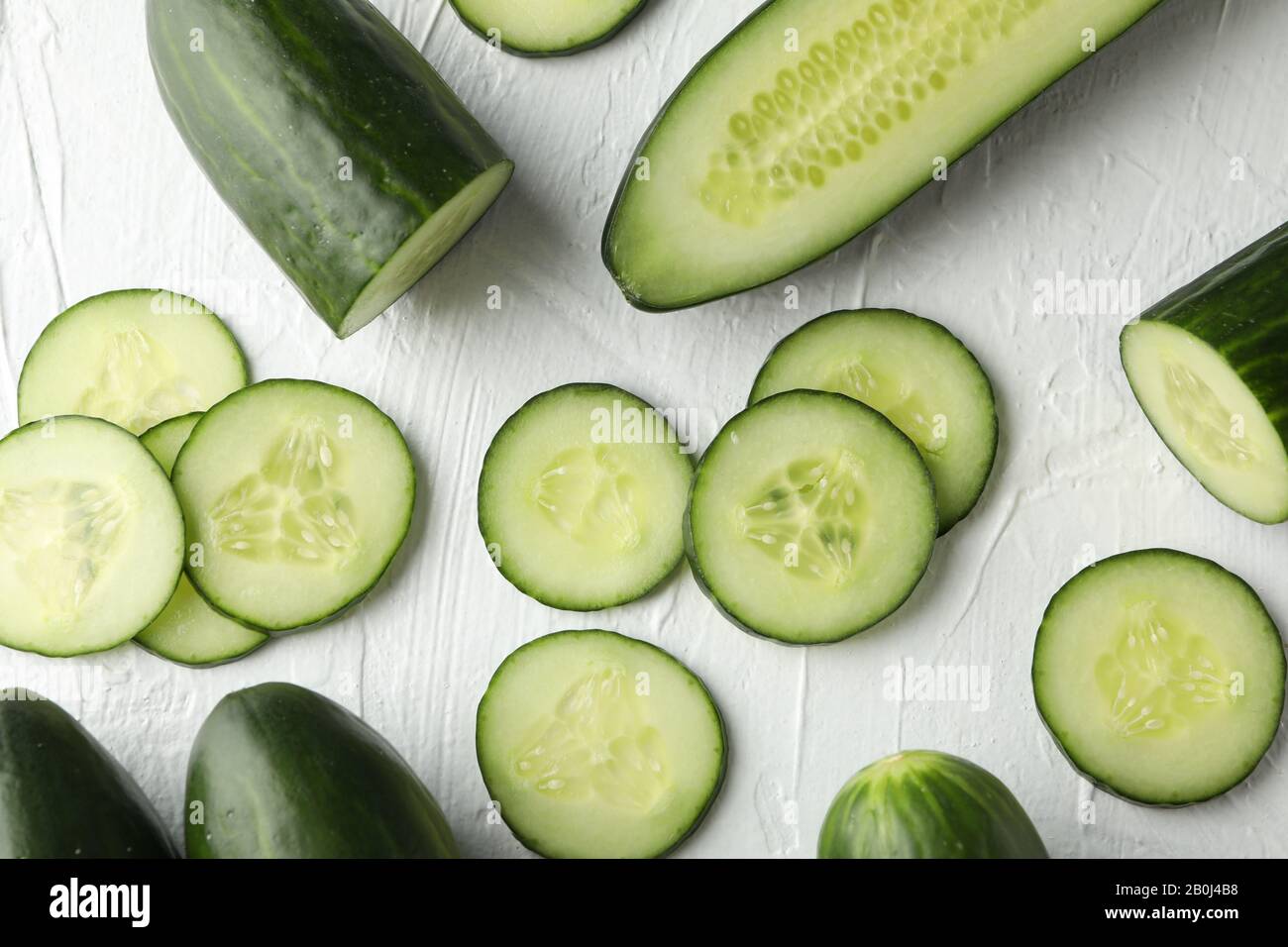 Cucumbers and slices on white background, top view Stock Photo - Alamy