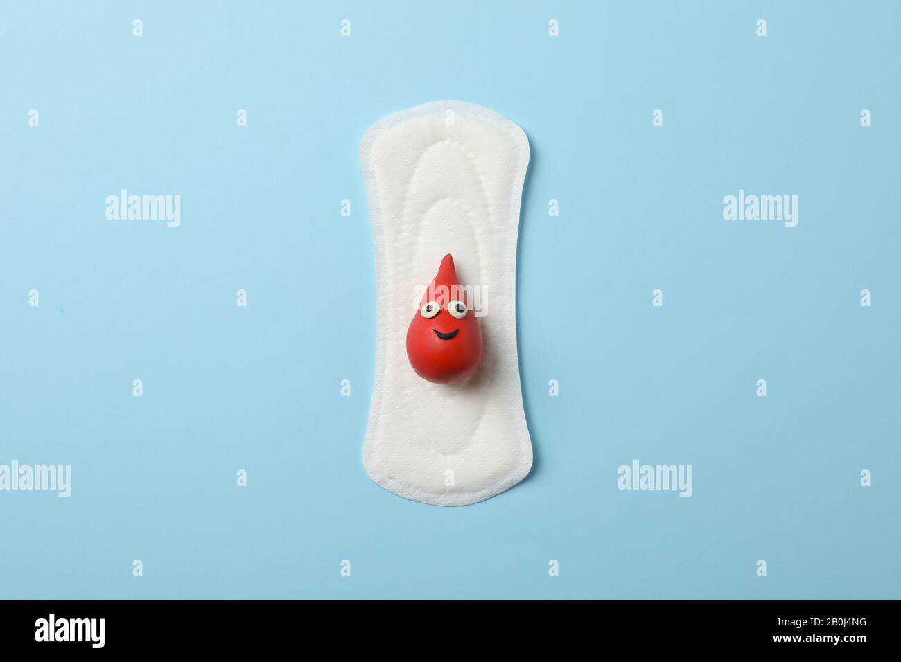 Sanitary pad with drop of blood on blue background, space for text ...