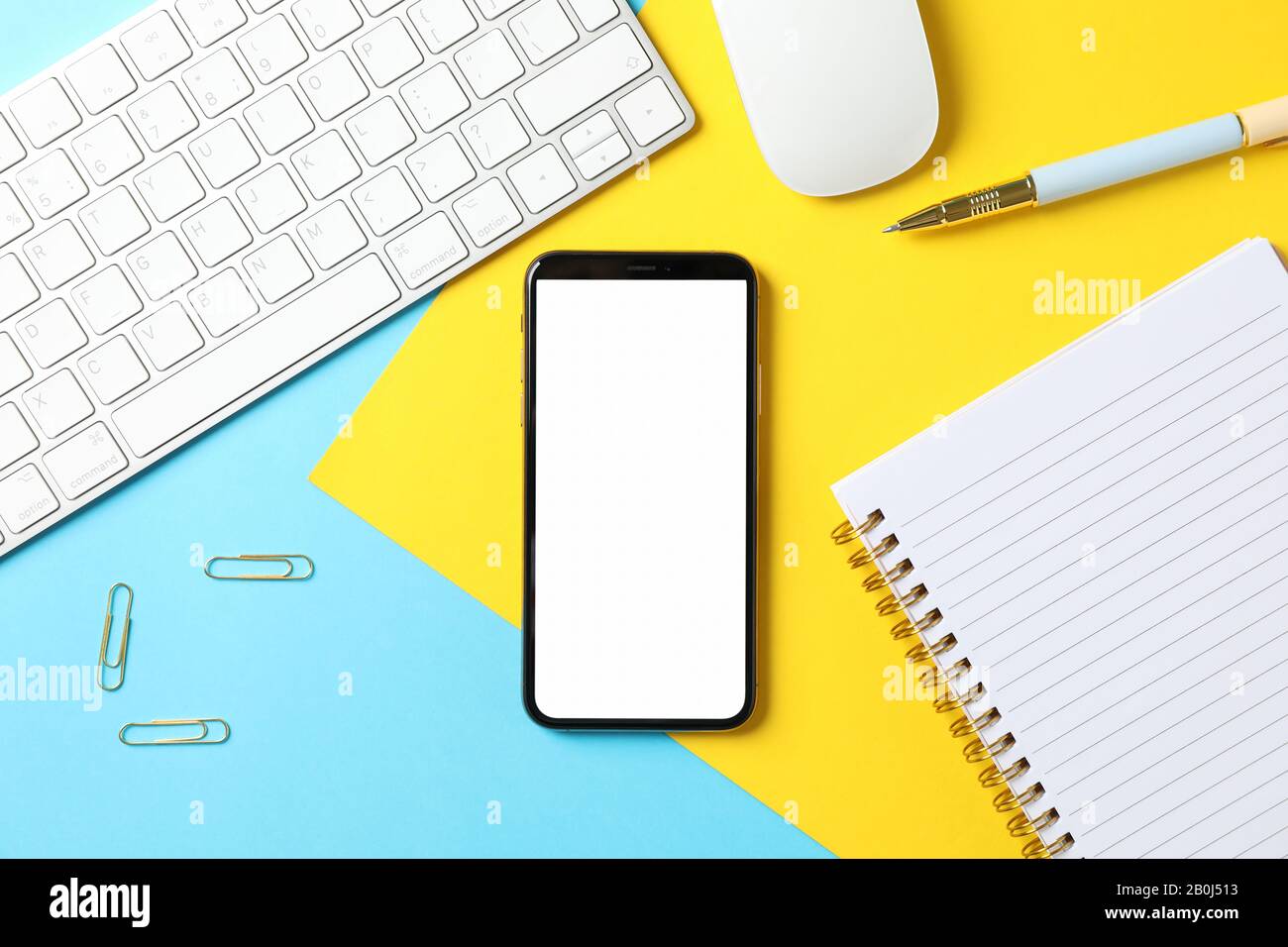 Workplace with phone with empty screen on color background, top view ...