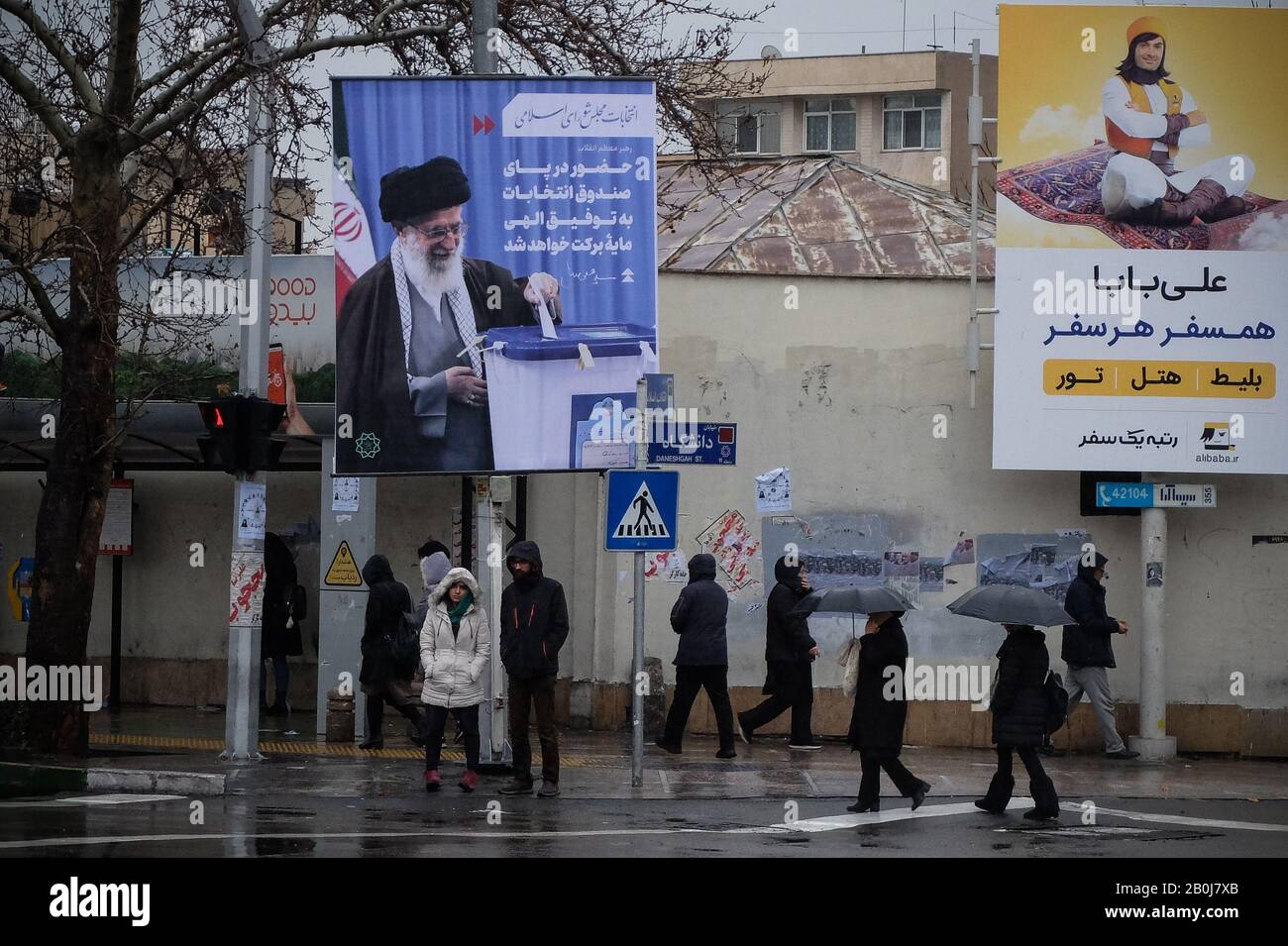 Tehran, Iran. 20th Feb, 2020. Iranians walk past an electoral billboard ...