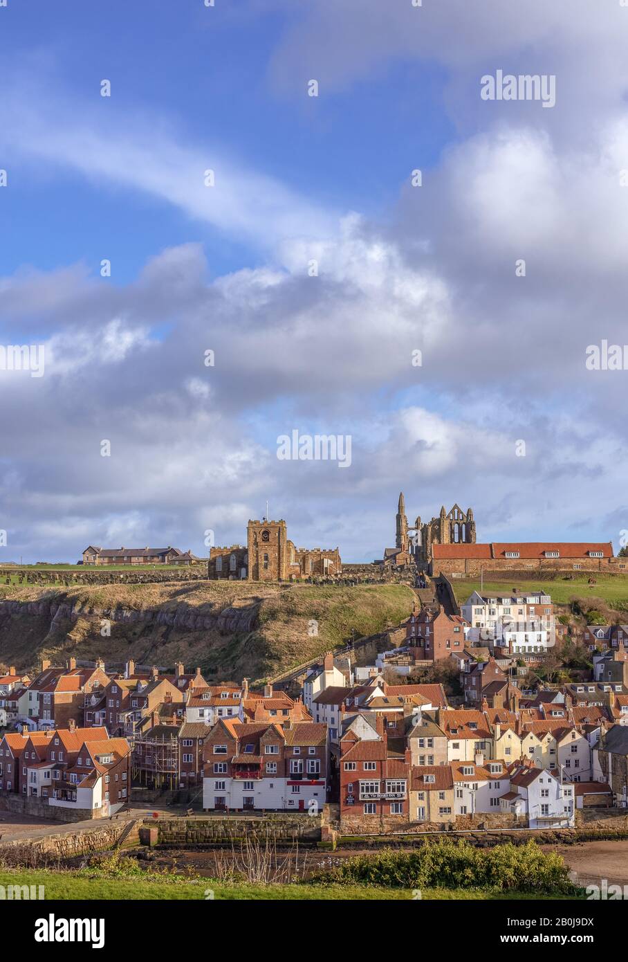 The outer harbour at Whitby. Houses nestle under the cliff with a ...