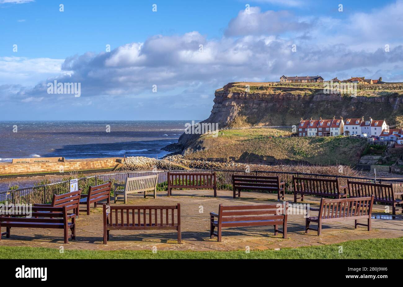 Whitby: A number of benches arranged in a curve on a cliff top ...