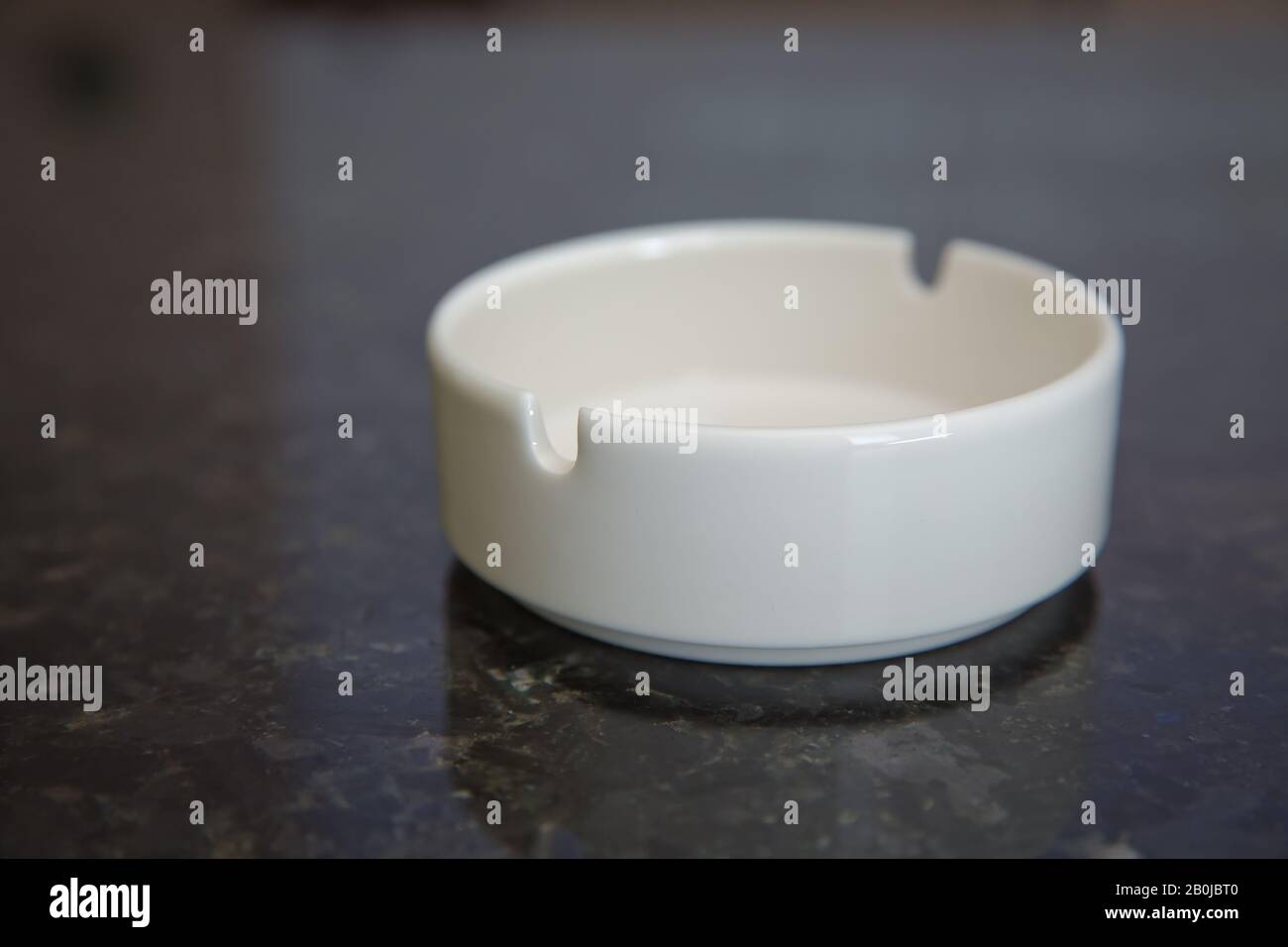 Close up, selective focus, shallow depth of view. Round glass ashtray ...