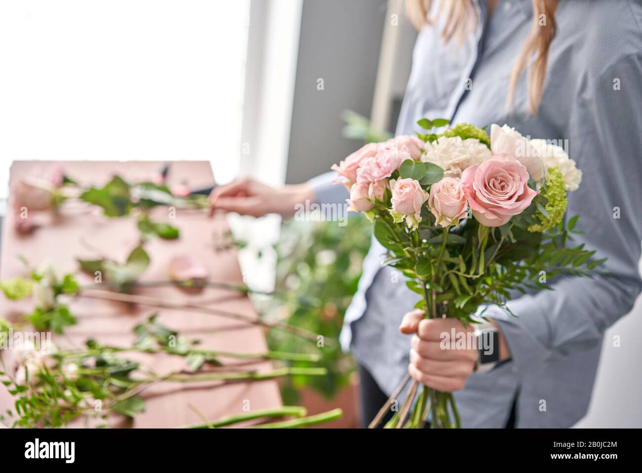 Floral shop concept . Florist woman creates flower arrangement ...