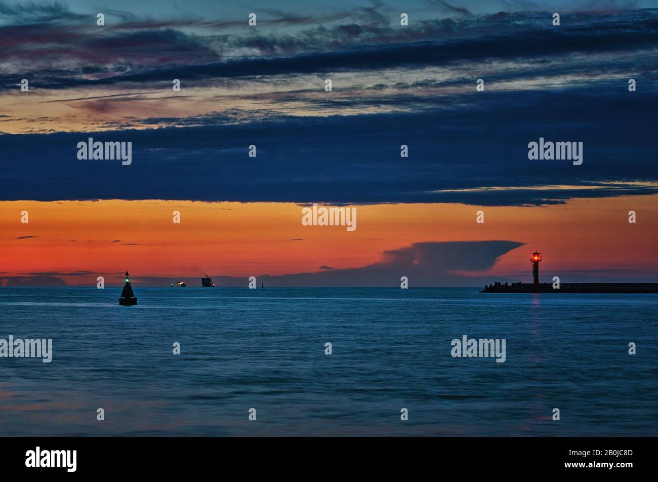 Colorful night scene on the Baltic Sea with lighthouse and ship in ...