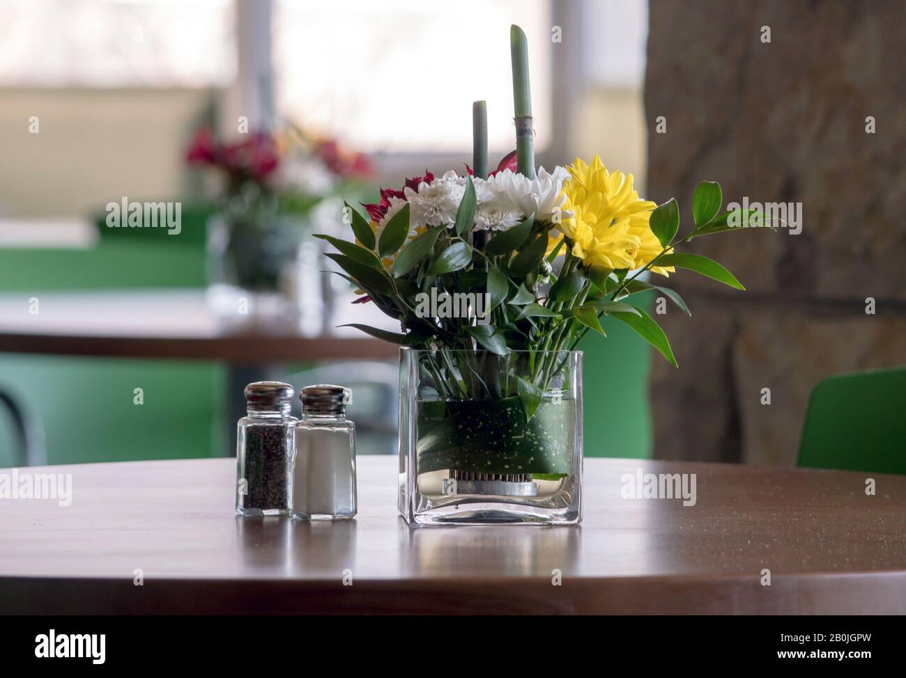 Salt and pepper shakers sit beside a colorful centerpiece of cut ...