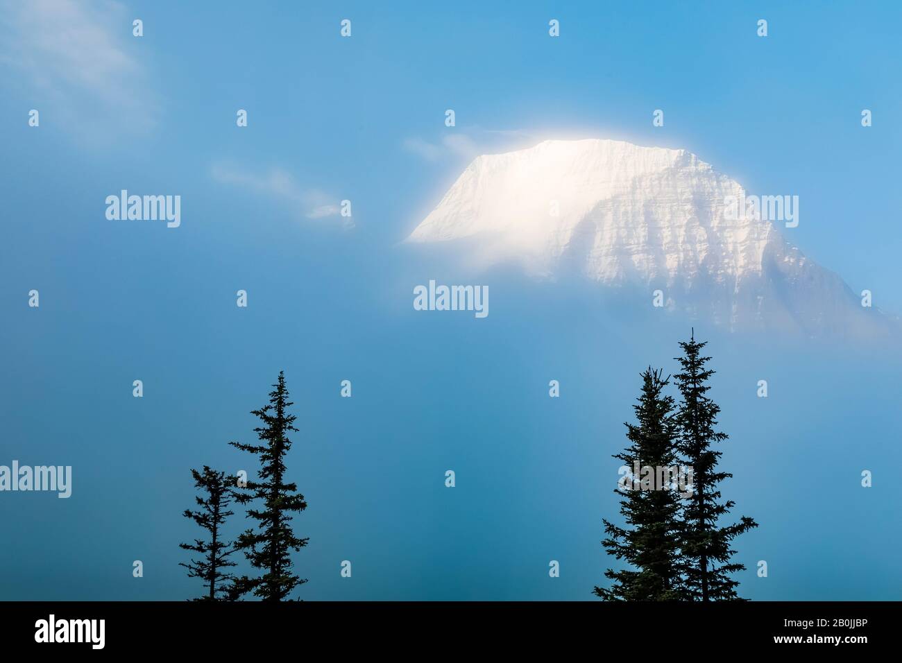 Mt. Robson summit viewed through fog from shore of Berg Lake, in Mount ...