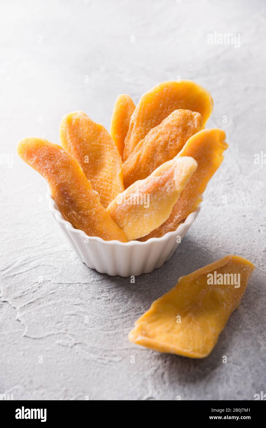 Dried mango chips on white background. Close up. Vertical format Stock ...