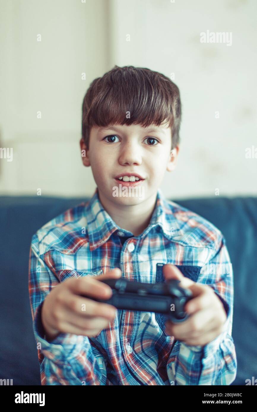 Little excited kid playing video game, holding controller Stock Photo ...