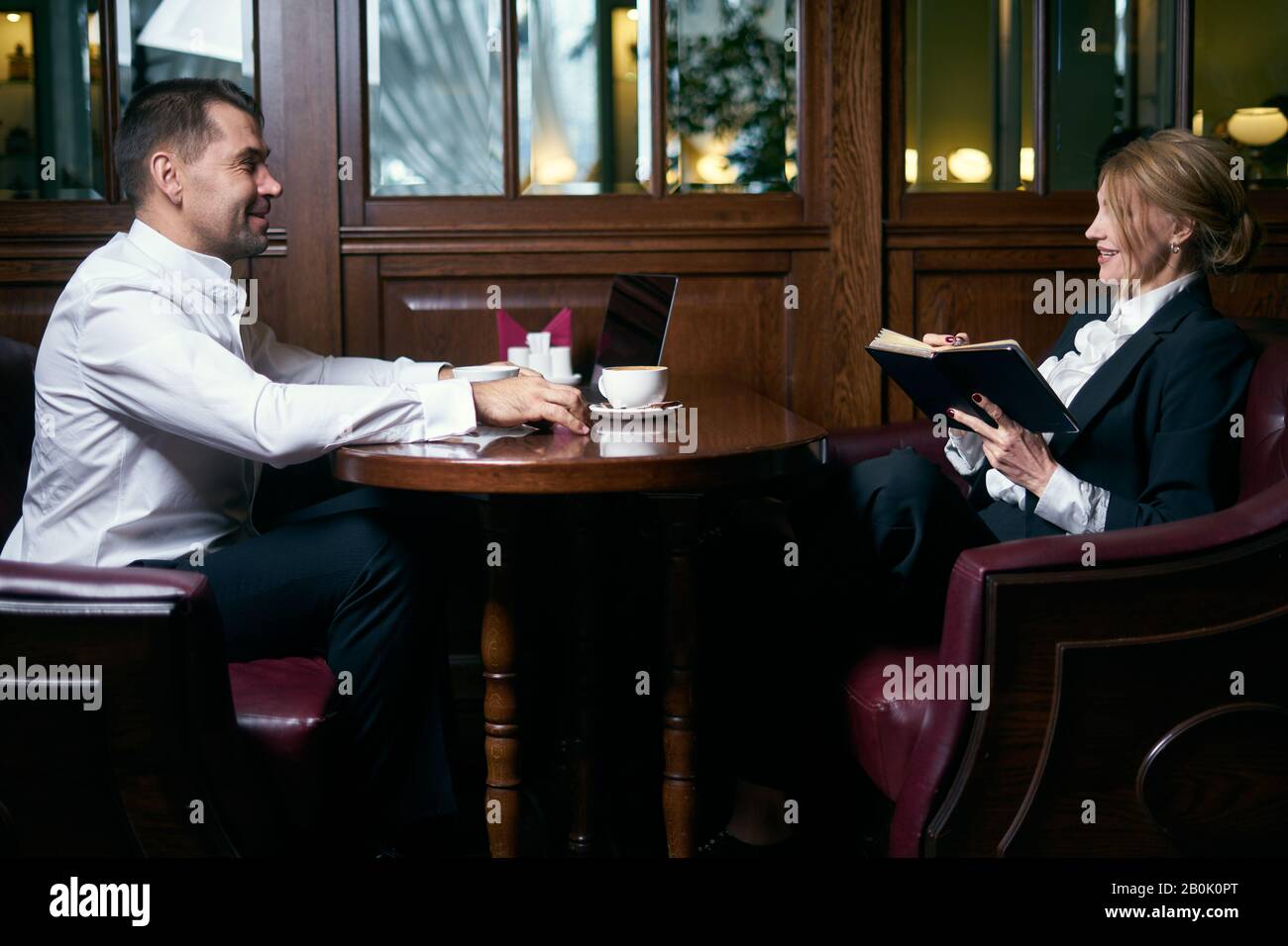Business people talking over coffee in a cafe Stock Photo - Alamy