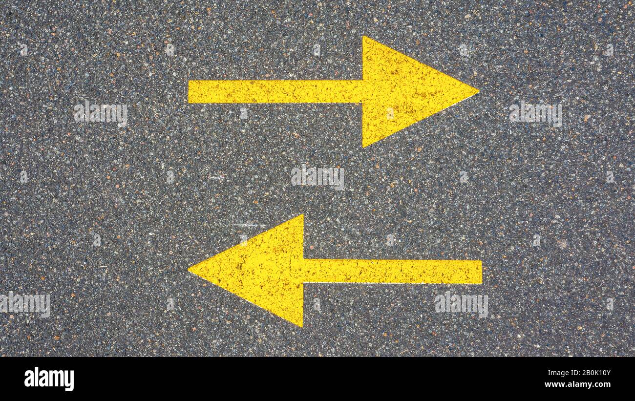 Two yellow arrows on the asphalt. Concept, radically different ...