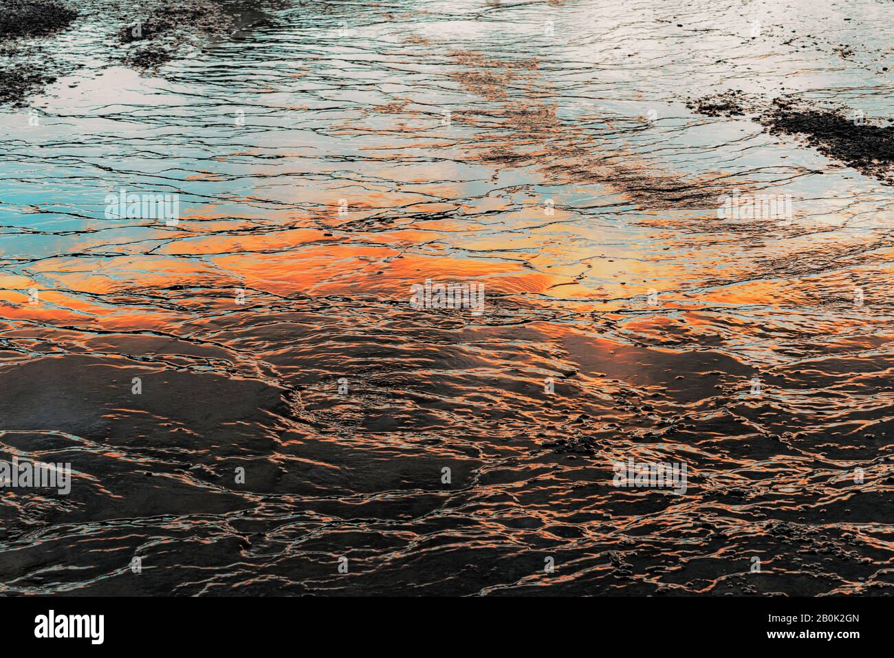 Textured flat wet rocky surface colorful sunrise and blue skies Stock ...