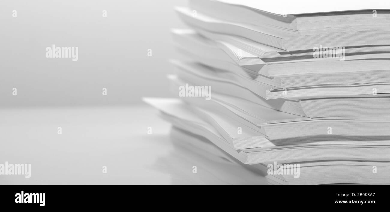 Several stacks of white paper on a white background Stock Photo - Alamy