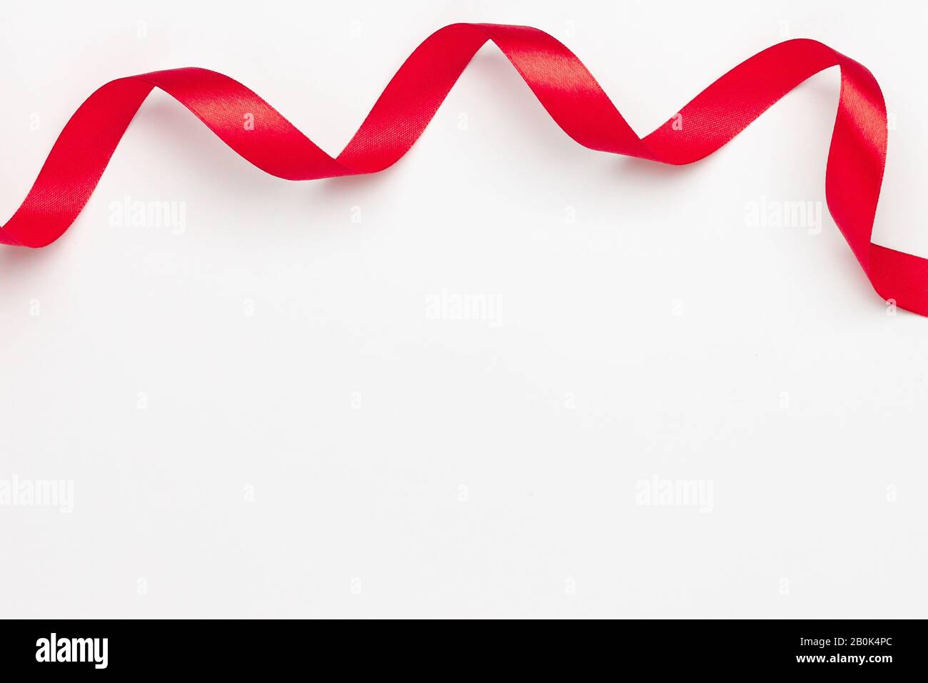 A red ribbon on a white background Stock Photo - Alamy