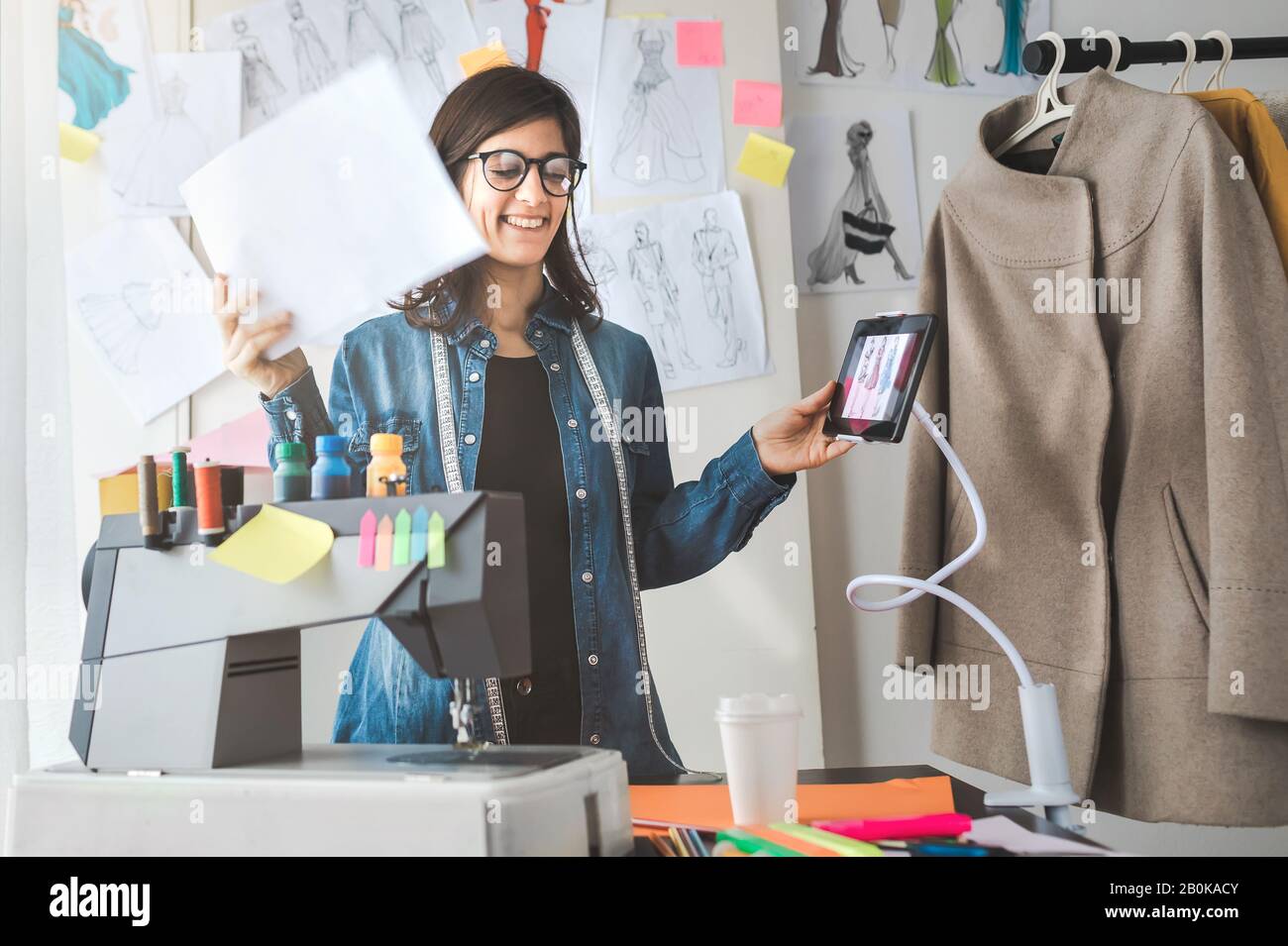 Portrait of young female fashion designer in her workshop. Young ...