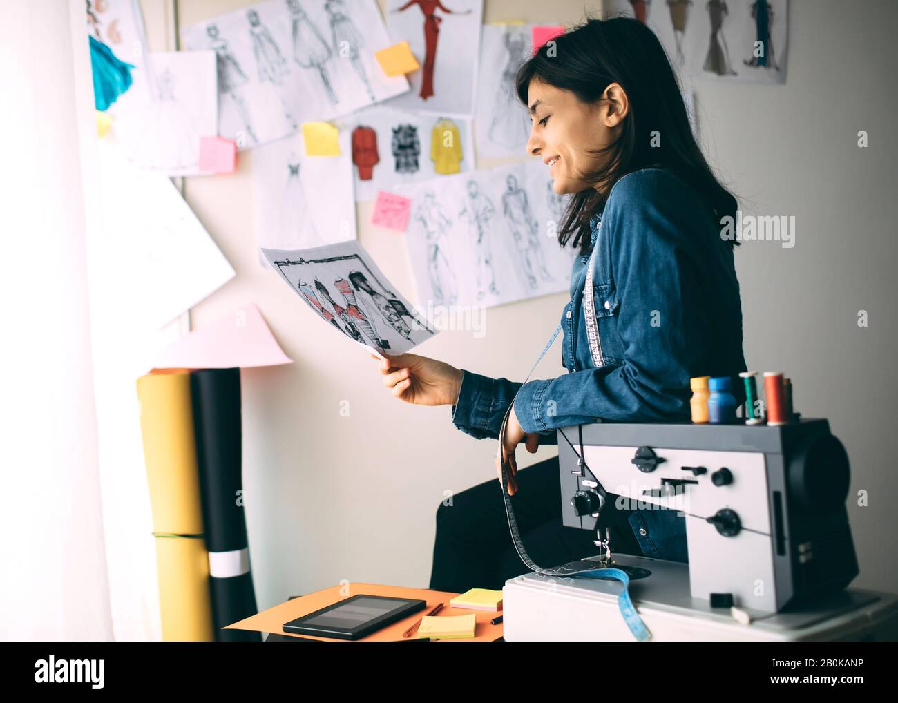 Portrait of young female fashion designer in her workshop. Young ...
