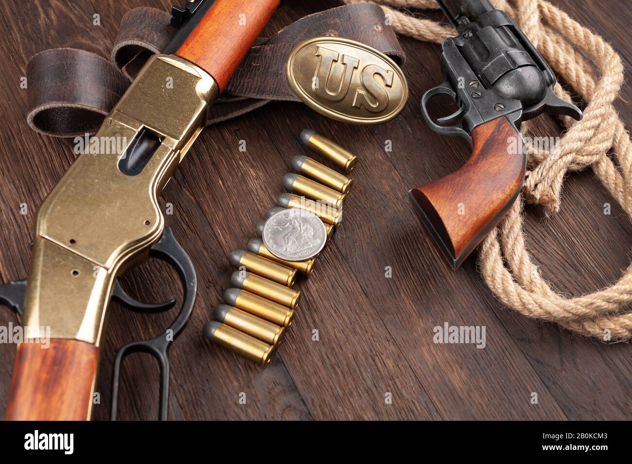 Wild west weapons and ammunition with silver dollar on wooden table ...