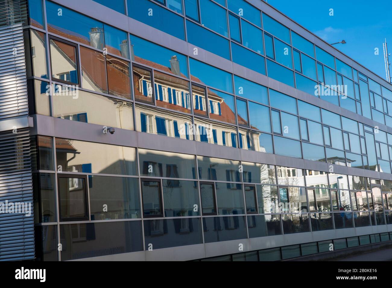 Reflective glass facade of a building with a house Stock Photo - Alamy