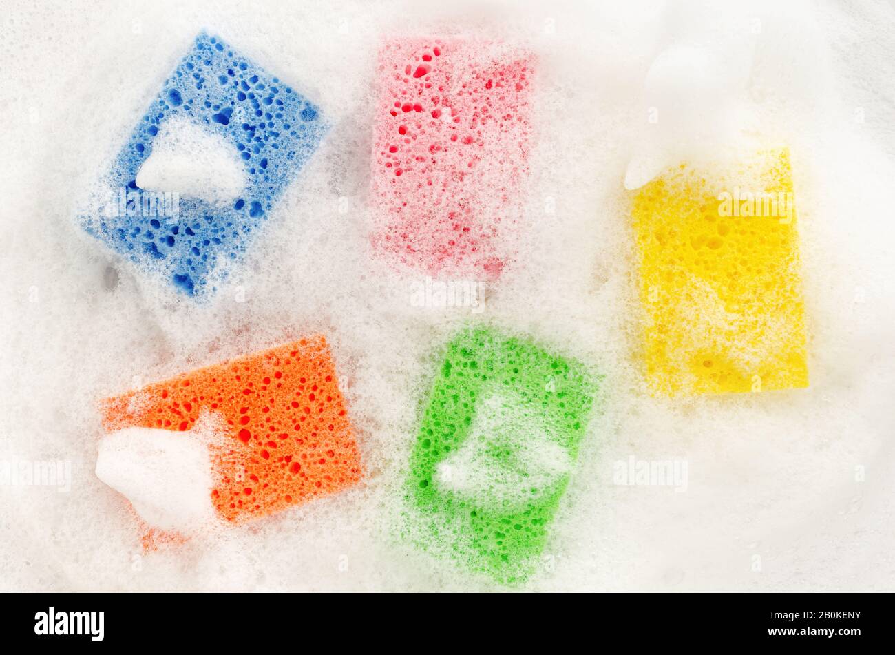 Multicolored soapy sponges with foam on white background. Cleaning ...