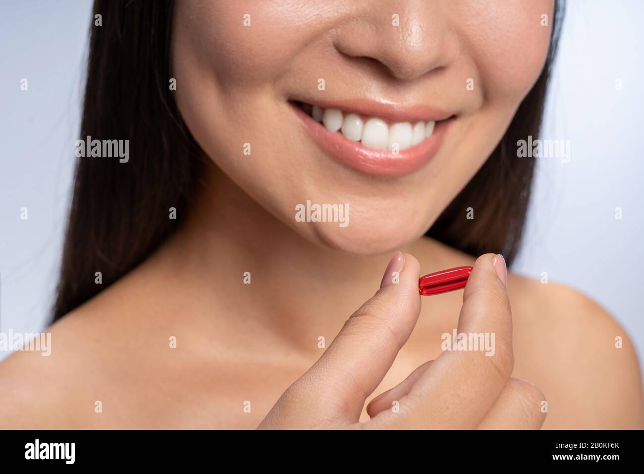 Positive delighted female person taking jelly tablet Stock Photo - Alamy