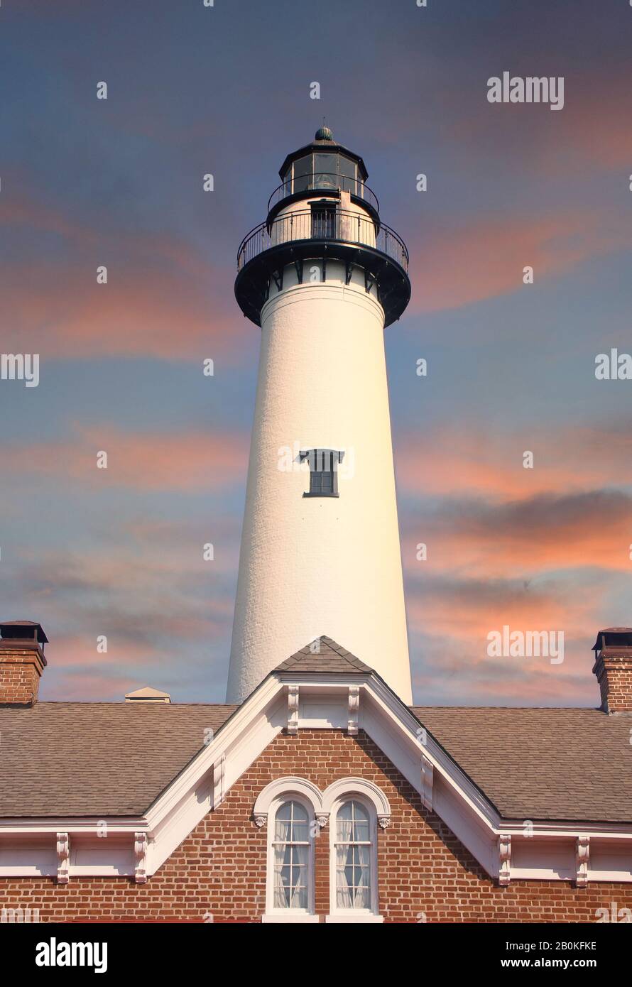 White Lighthouse Behind Red Brick House Stock Photo - Alamy