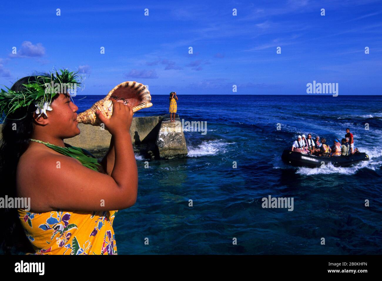 COOK ISLANDS, ATIU ISLAND, GIRL BLOWING INTO SEASHELL (HORN), GREETING ...