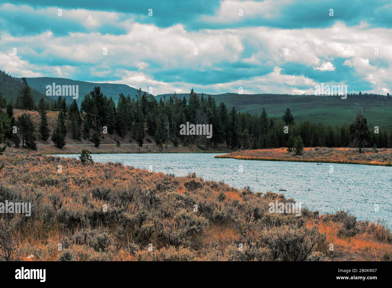 Peaceful environment, river running through valley with fields and ...