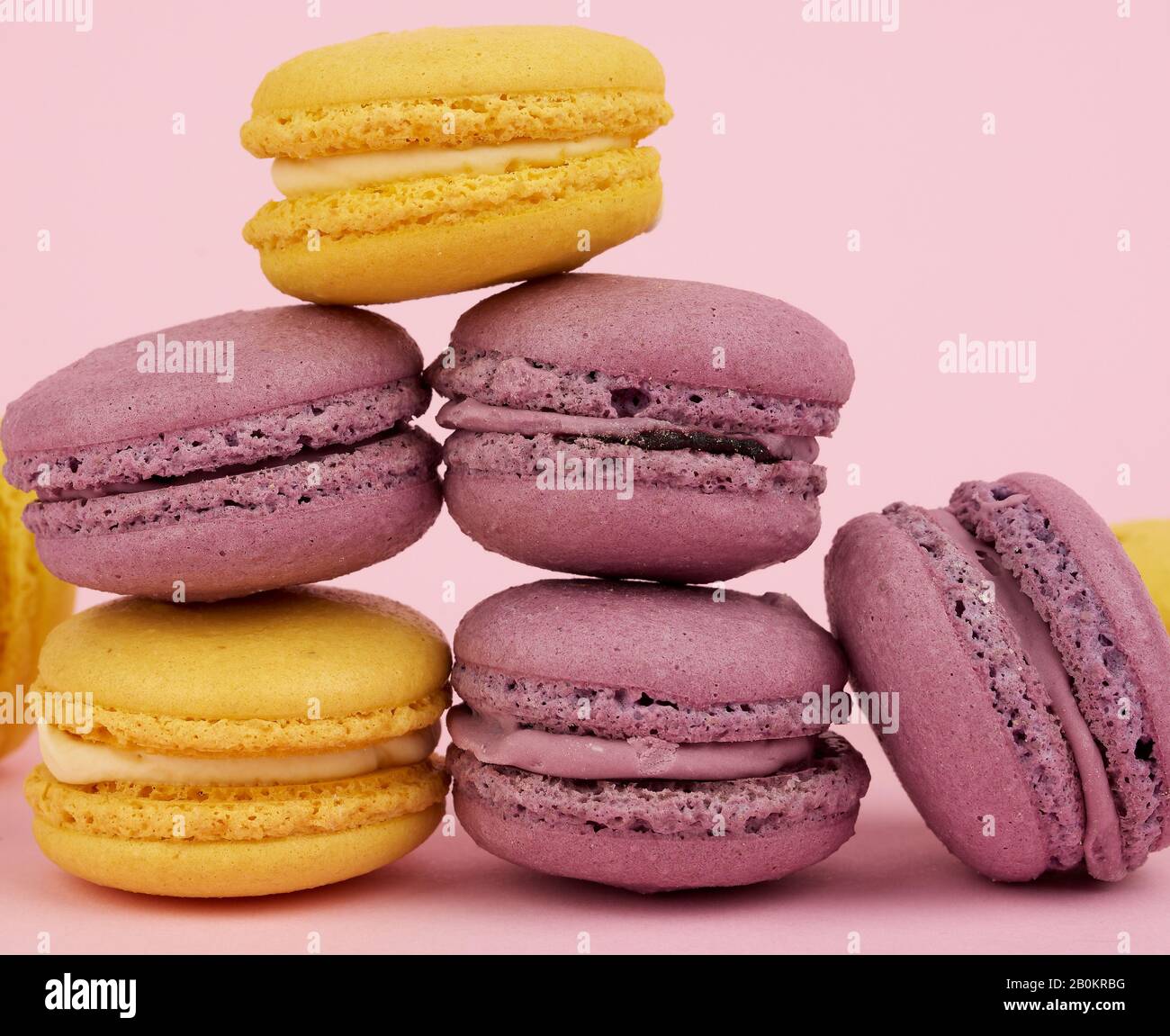 yellow in purple round baked macaroon cakes on a pink background ...
