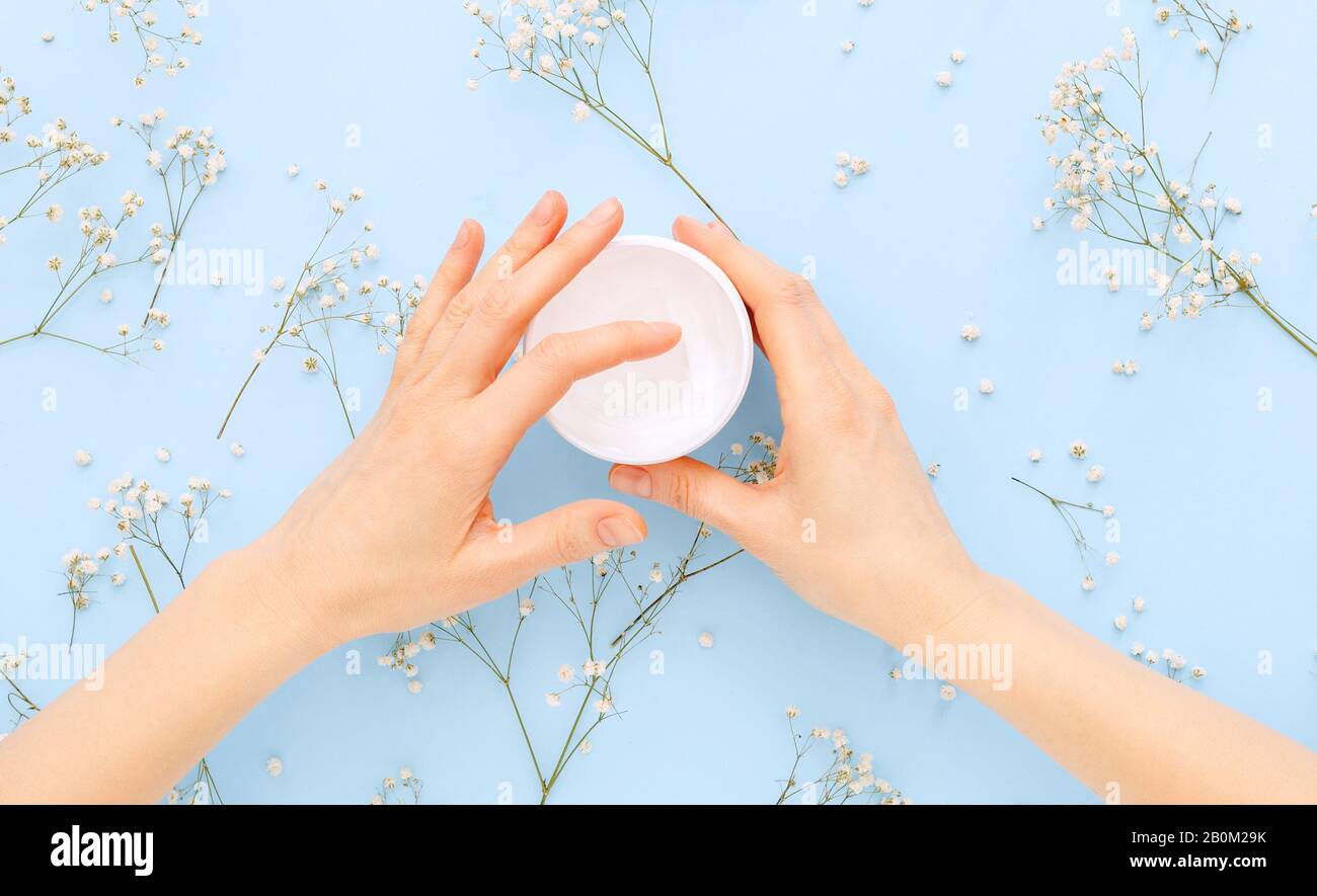 Hand cream, female hands applying organic natural cream cosmetics on a ...