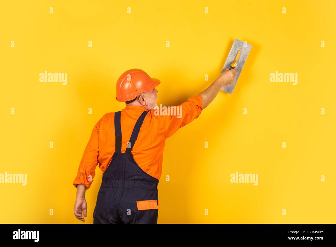 plaster trowel spatula on yellow drywall plasterboard. Plasterer in ...