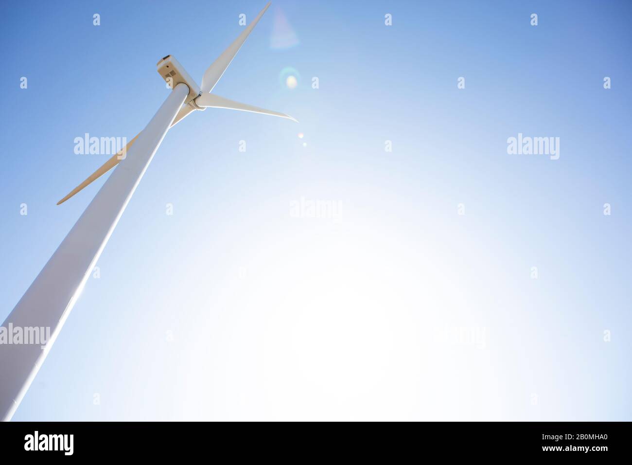 Wind Turbine against blue sky with sun flare Stock Photo - Alamy