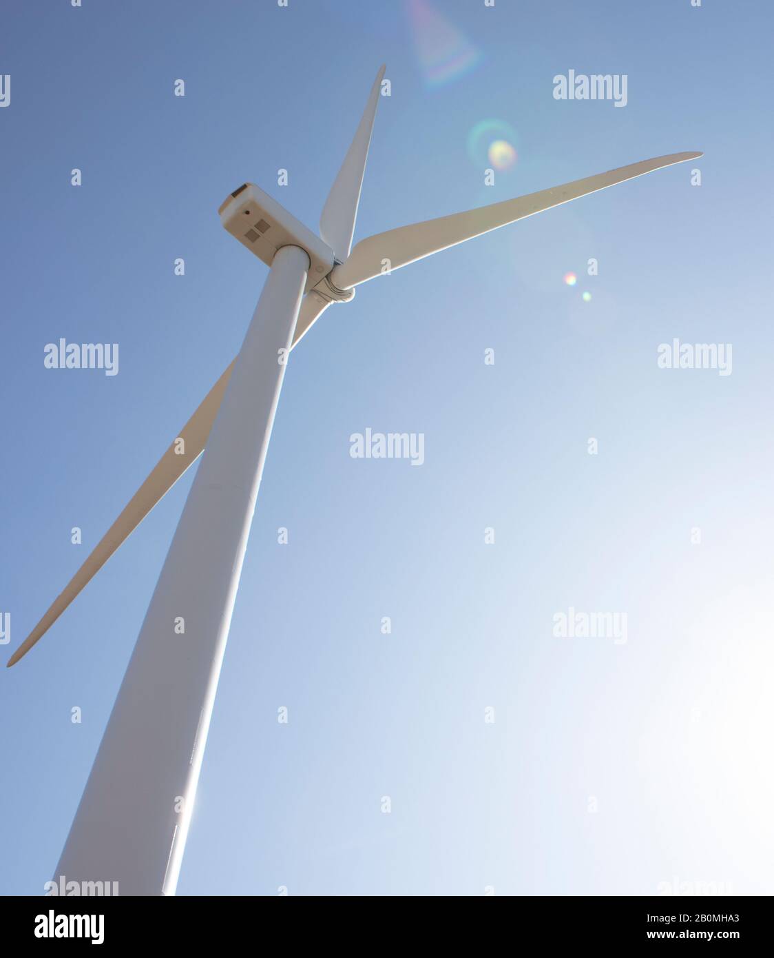 Wind Turbine against blue sky with sun flare Stock Photo - Alamy